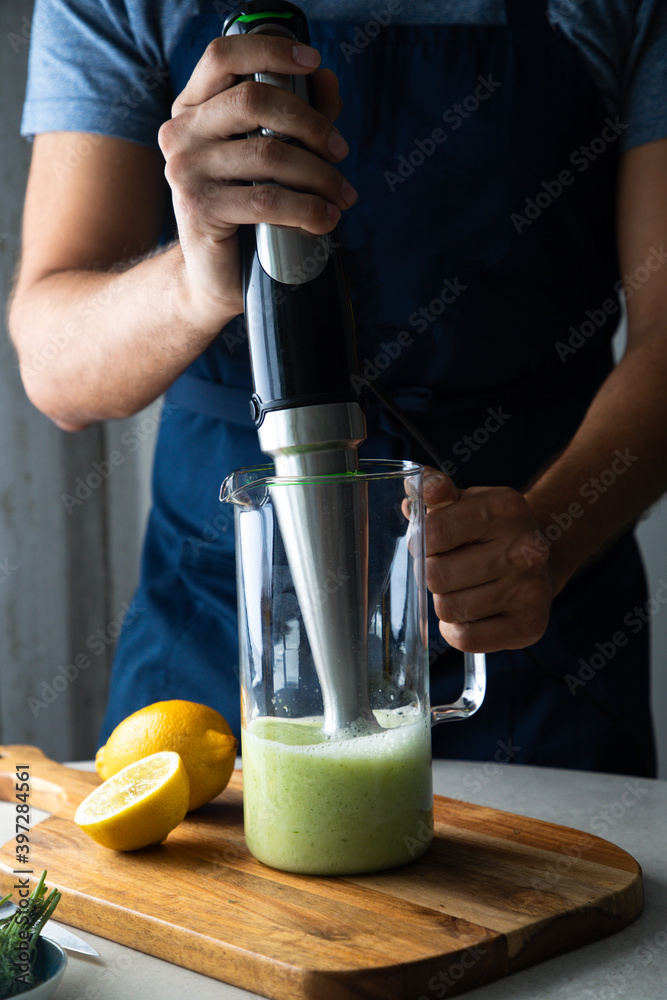 Crop unrecognizable person using blender while preparing vegan detox ...