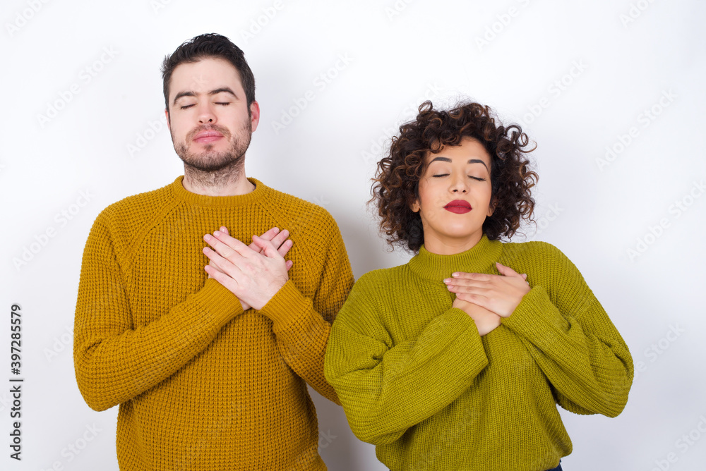 Young couple wearing knitted sweater standing again closes eyes and ...