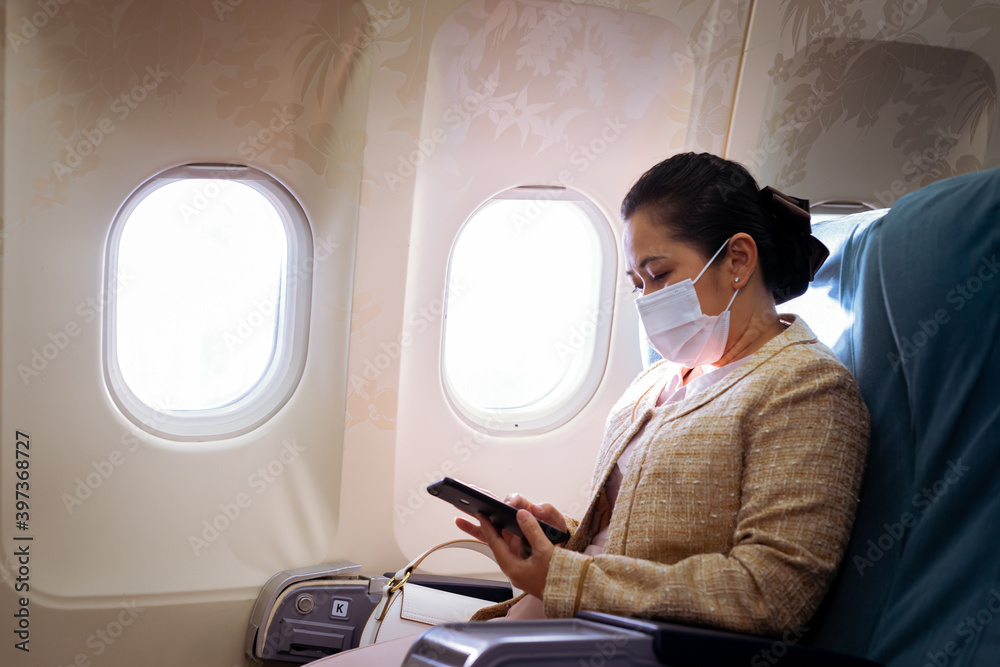 Business woman using a smartphone in the airplane before the flight ...