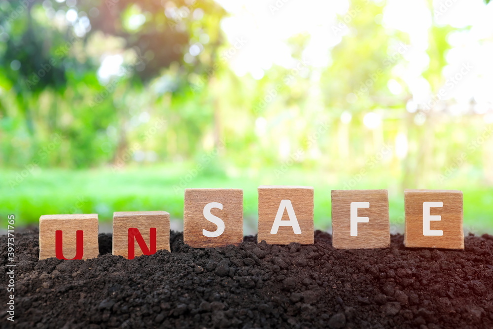 Hand changing word unsafe to safe in wooden blocks on natural ...