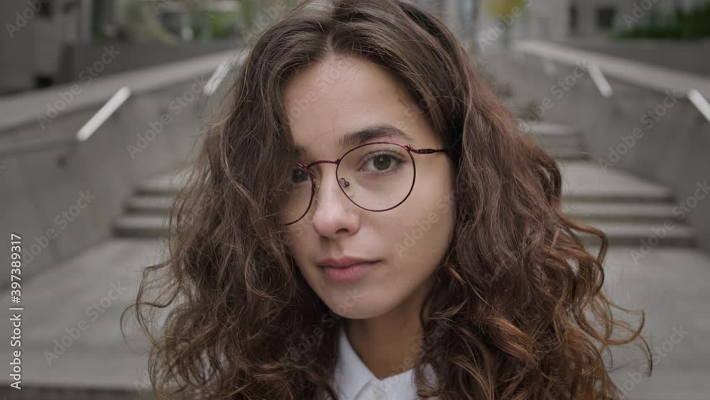 Face Of Young Girl With Long Curly Hair. She Is Very Beautiful And In Glasses. Stock ビデオ | Adobe ...