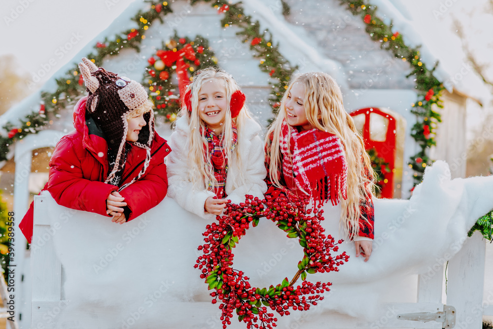 Pretty blond sisters in winter red and white coats and cheerful ...