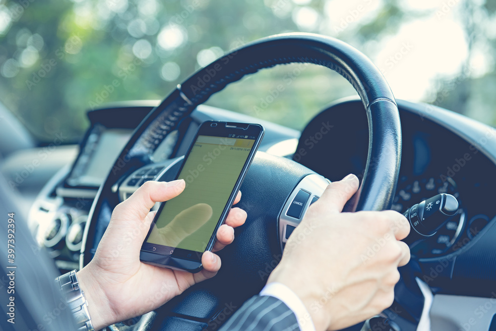 Hand using phone sending a text while driving to work ,businessman ...