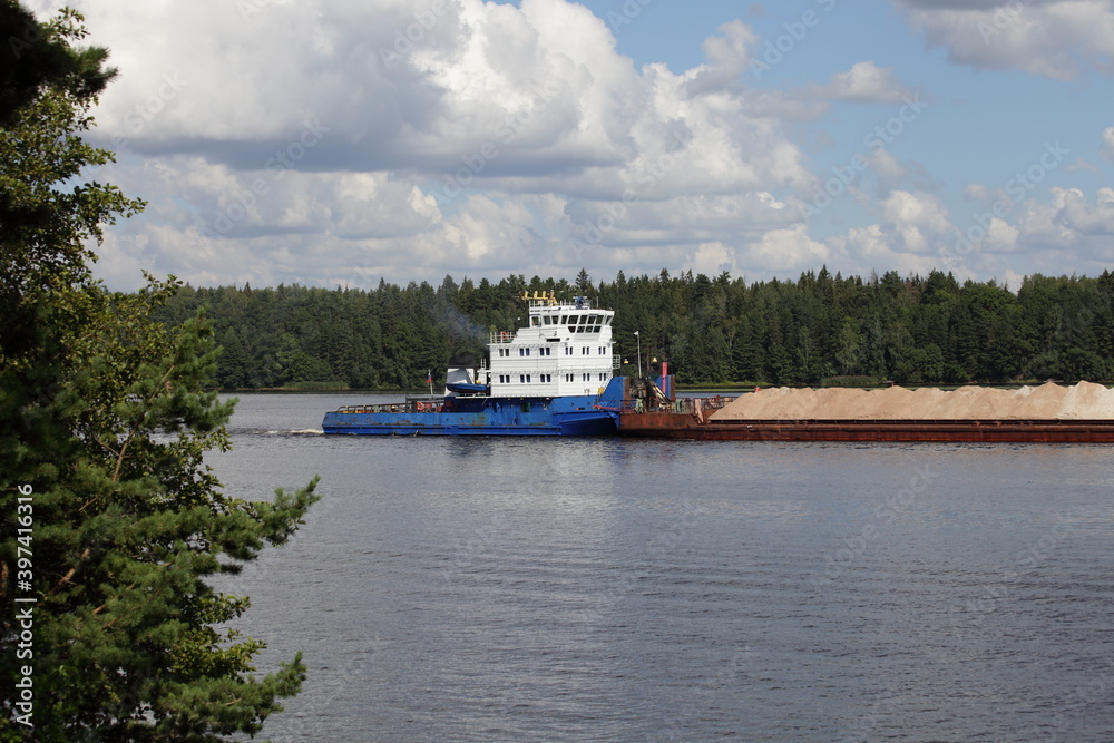 Russian pusher cargo tug ship carries a loaded barge on the Volga river ...