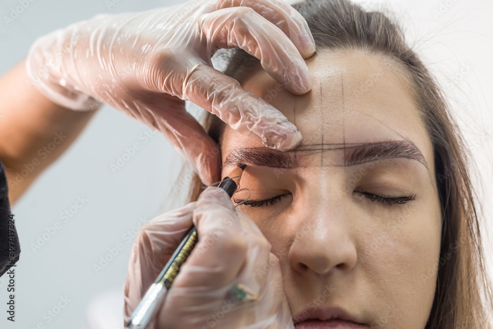 Professional facial care concept. eyebrow master draws the shape of the ...