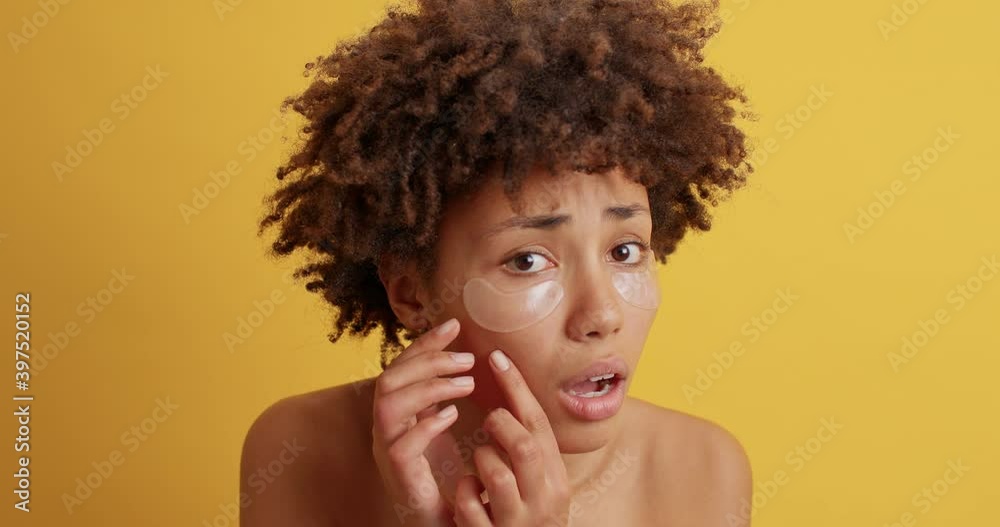 Dissatisfied curly haired woman has problematic skin tries to reduce ...