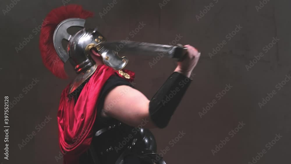 Royal savage legionary in black armour with shield and helmet poses in ...