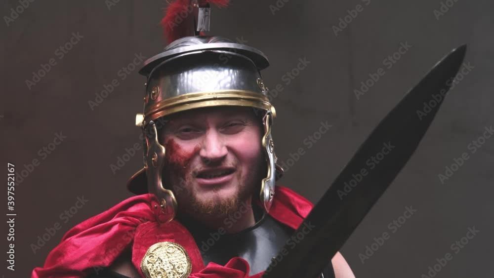 Dressed in black armour with helmet and red mantle military roman ...
