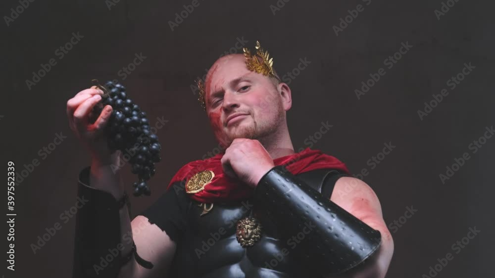 Status and bald roman soldier with wreath on his had in dark armour ...