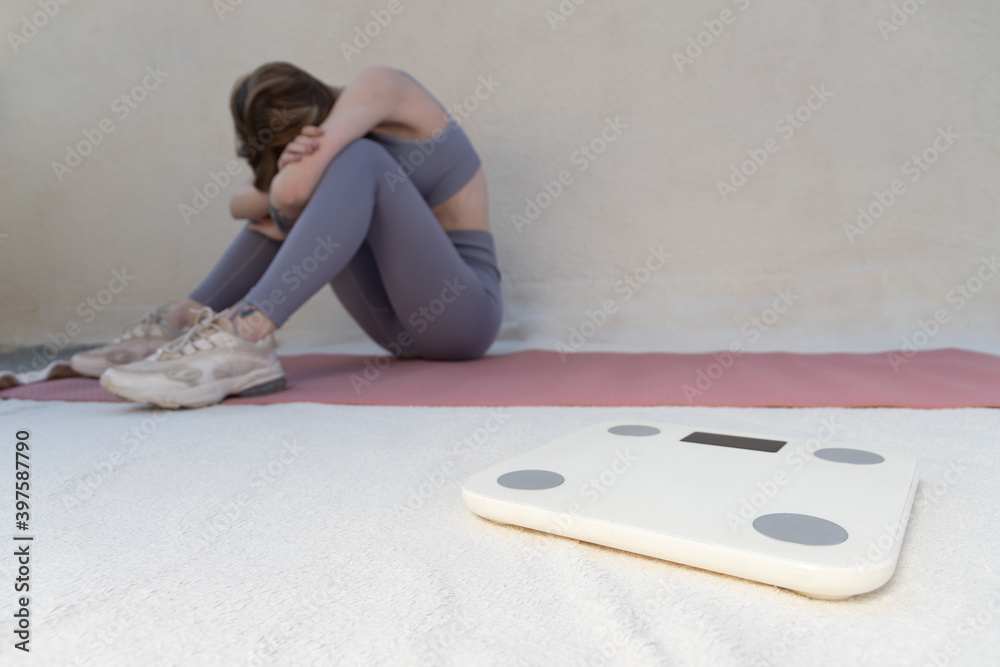 Weight loss is not a concept. Scale and depression, upset and sad woman ...