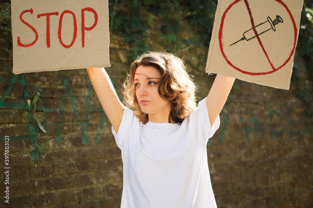 Young protesting woman in white shirt and jeans holds protest sign ...