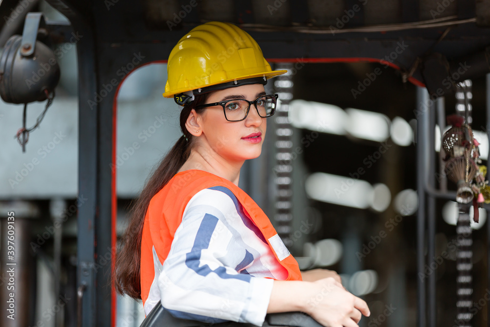 Female industrial worker wearing safety uniform, glasses and yellow ...