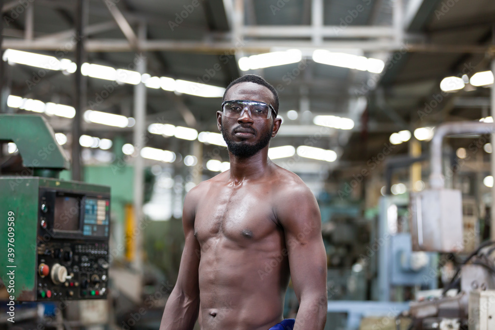 Portrait of male engineer take off safety uniform and show muscles body ...