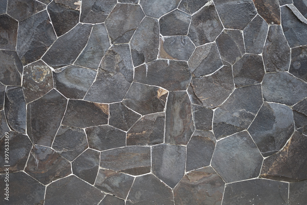 The neatly arranged stone plates on the wall look like abstract ...