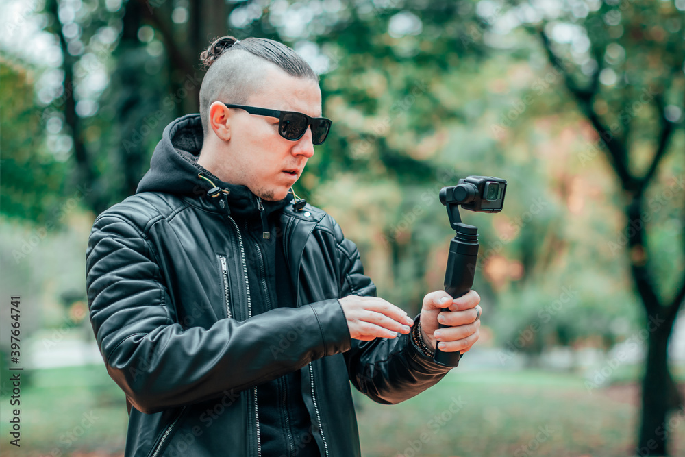 Blogger in Black Clothes and Sunglasses Making Video Using Action ...