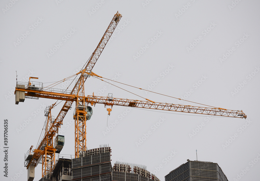 grúa pluma trabajando en edificio de altura Stock Photo | Adobe Stock