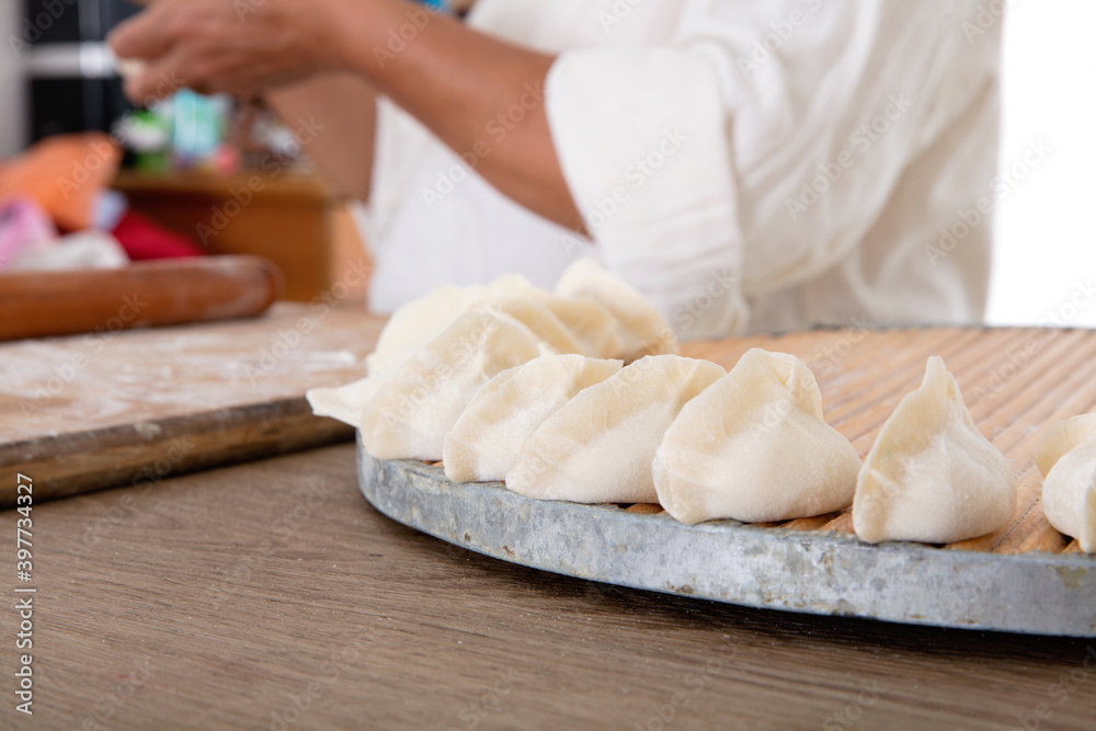 Chinese women busy making dumplings in the kitchen during festivals ...