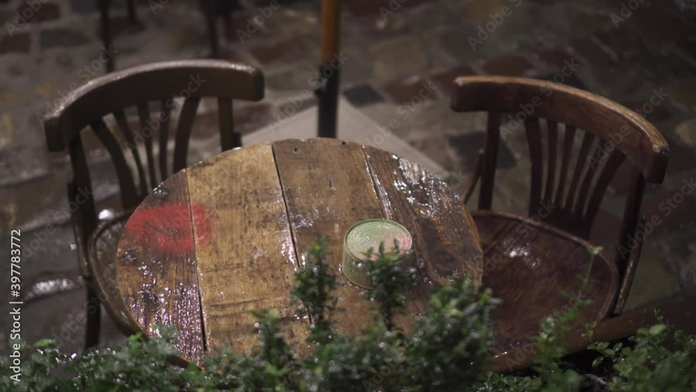 Vidéo Stock Wooden wet table at street cafe at night in heavy rain. Wet ...
