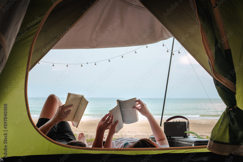 asian couple camping and reading book on beach with sea background on ...