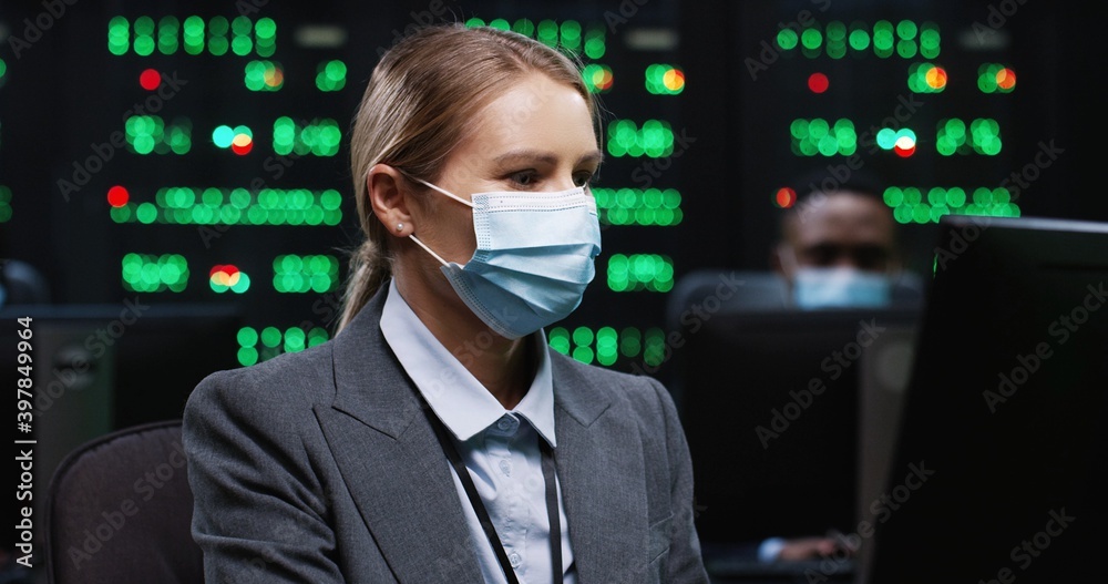 Caucasian woman IT programer working on desktop computers in data ...