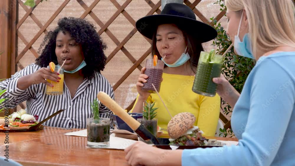 Young mixed race women enjoy brunch together and cheering with ...