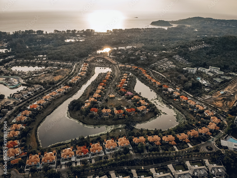 Top view of sunny green city filled with a huge number of trees and ...