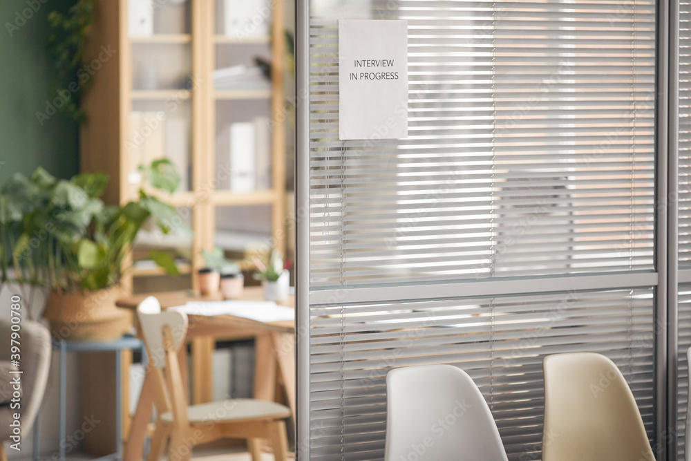 Background image of empty office room with sign Interview in progress ...