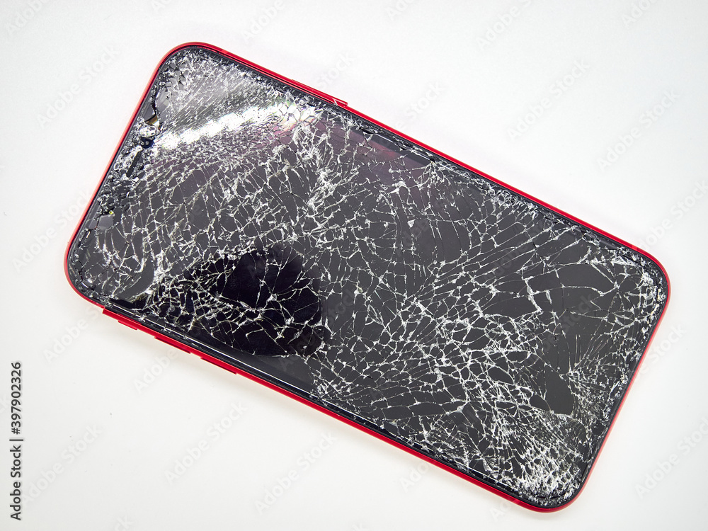 A modern red smartphone with a broken glass display and a damaged ...