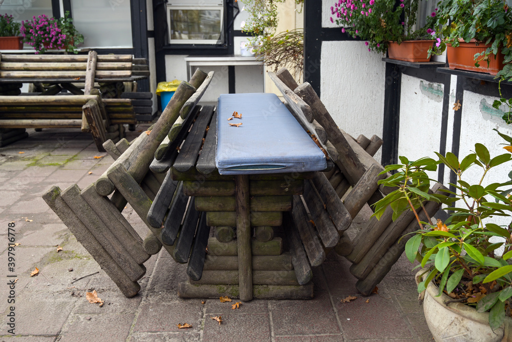 Foto de Rustic benches and tables pushed together in a closed terrace ...