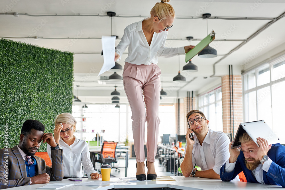 angry woman boss criticizing frustrated employees at work place in the ...