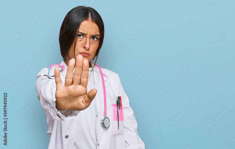 Beautiful hispanic woman wearing doctor uniform and stethoscope doing ...