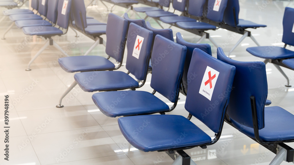 Empty row of benches in airport waiting area with "No seating" marking ...