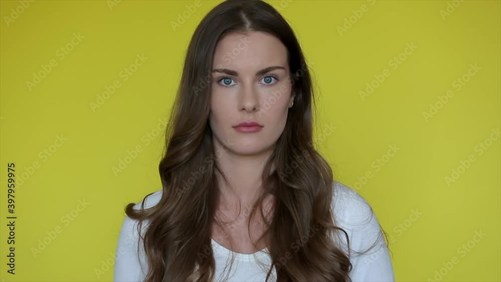 Negative woman waving no head in yellow studio. Portrait of serious ...