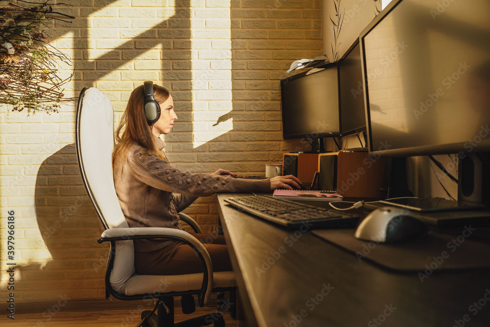 Young woman in headphones having video call via computer at home ...