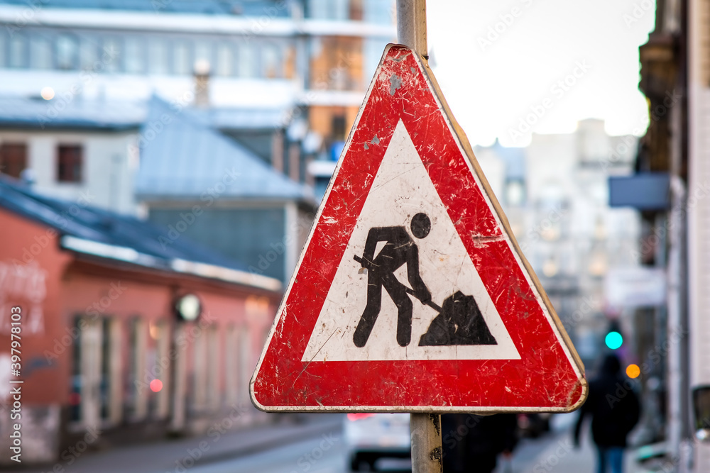 Roadworks sign on a busy street in a city, traffic warning sign during ...