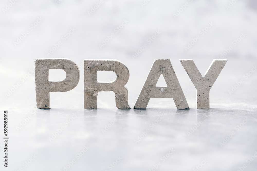 Word PRAY made with cement letters on grey marble background. Copy ...