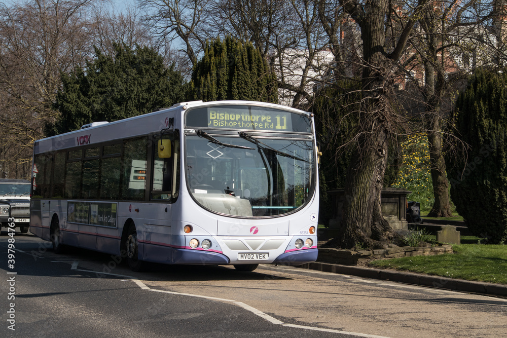 First branded bus in corporate livery on the street in sunshine. Public ...