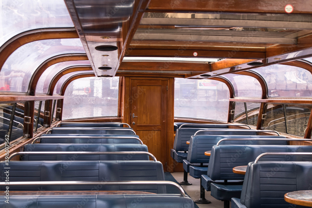 Interior seating inside a glass roofed sightseeing canal cruise trip ...