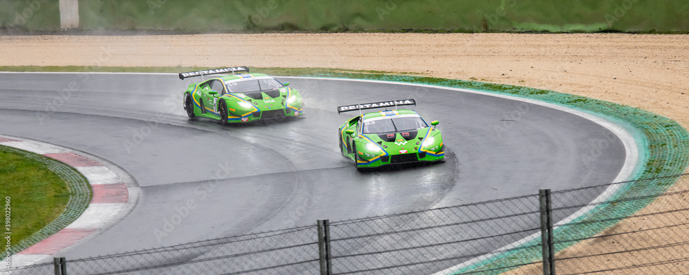 Wet race motorsport Lamborghini Huracan couple racing cars spraying ...