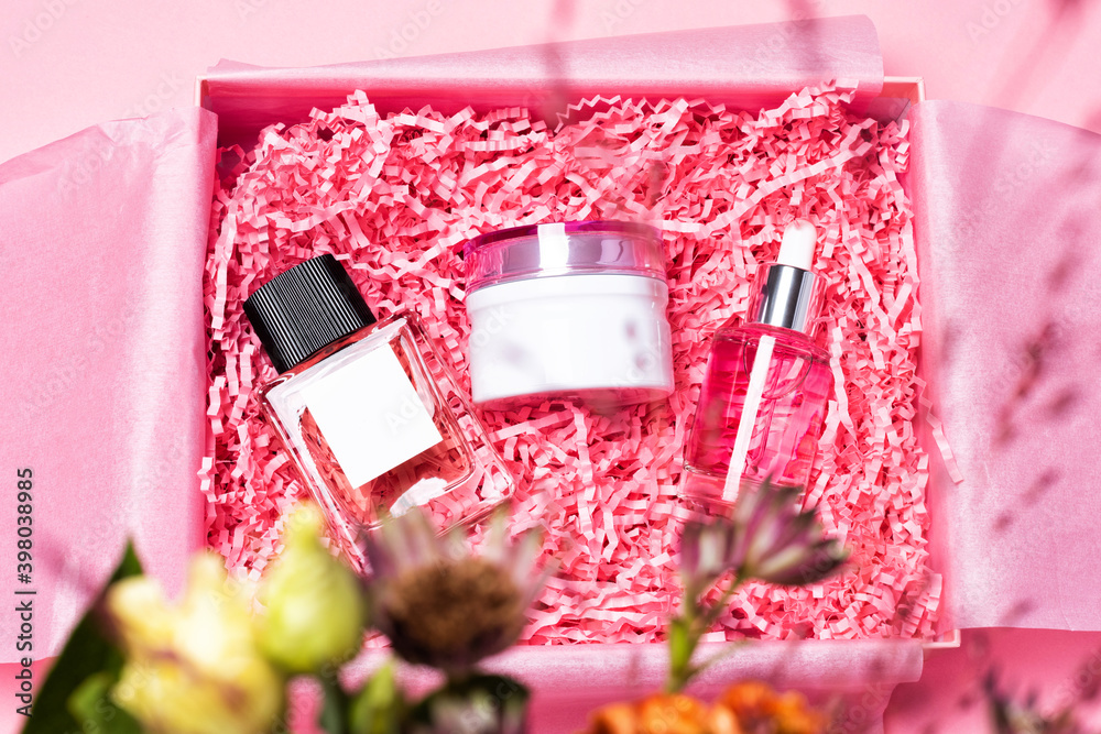 Beauty box with cosmetics filled with shredded pink paper packing ...