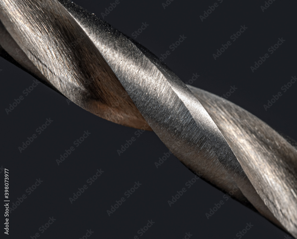 Sharp cuts of screw-threads on a metal drill, macro view. Structure of ...