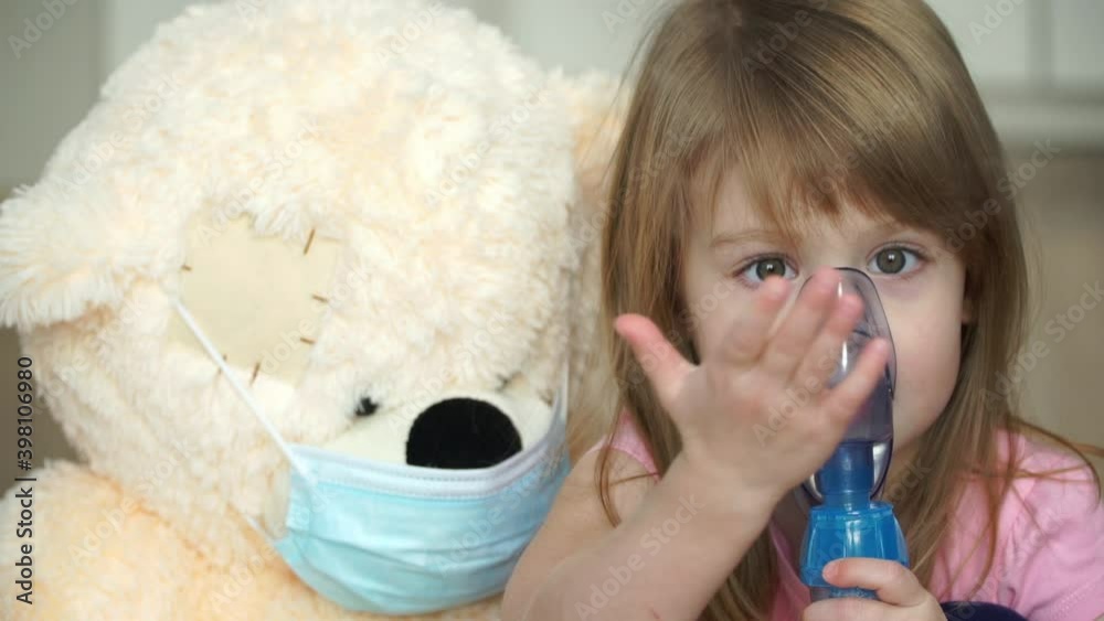 Portrait of little girl does procedure with medication nebulizer and ...