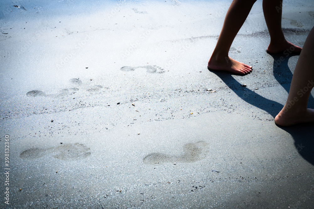 zwei Personen gehen Barfuß am Strand im Sand, Fußspuren nebeneinander ...