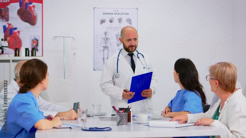 Medical staff listening to lecture, asking questions and taking notes ...
