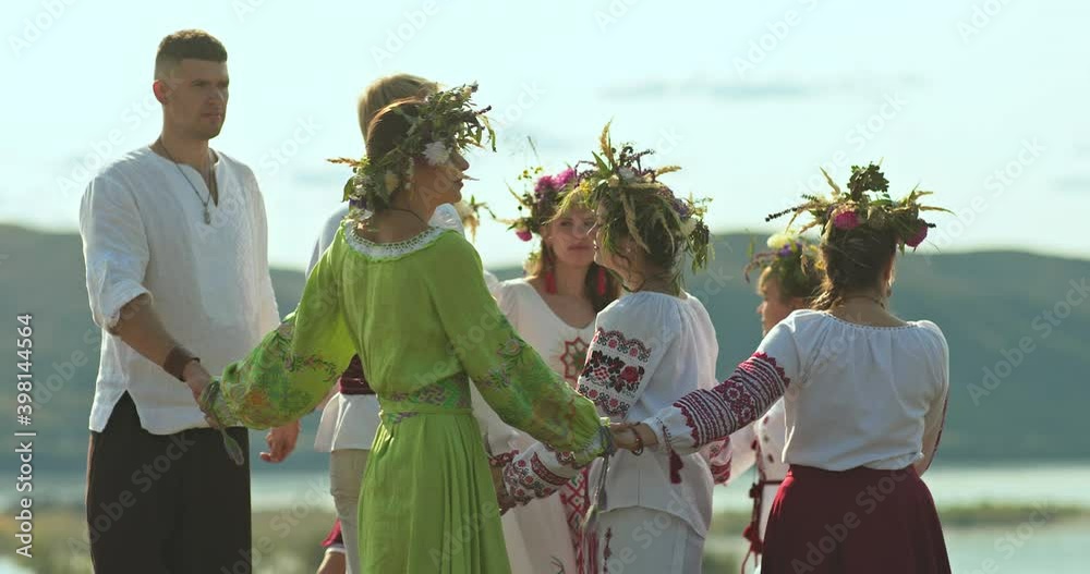 Beautiful and young women with wreaths on their heads dance in folk ...