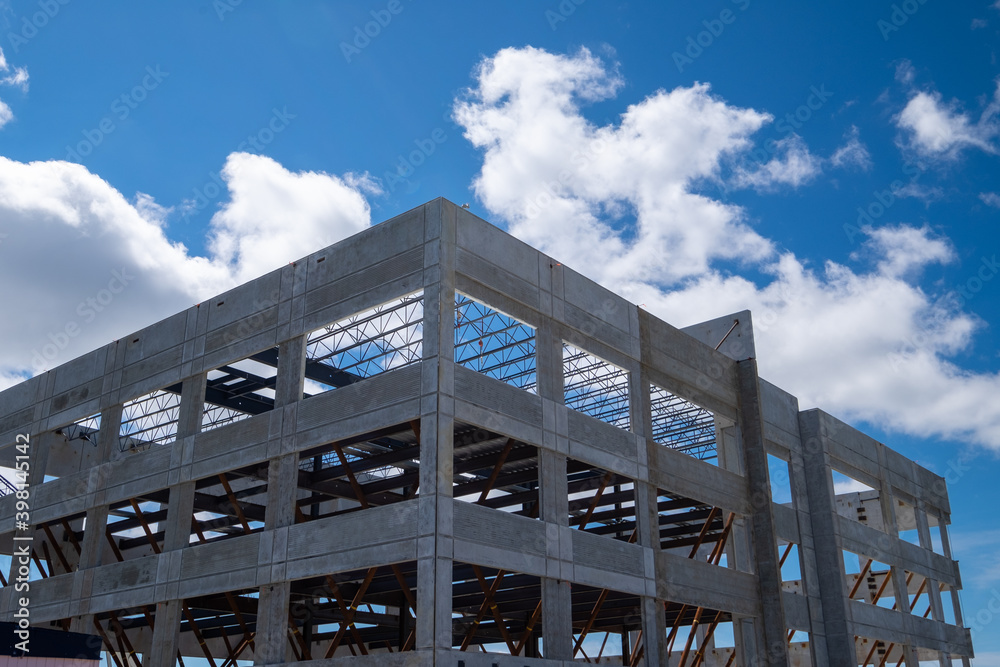 Multiple story precast grey concrete building with steel beams. The ...