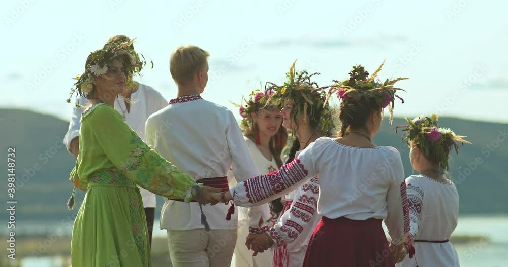 Slavic people lead a round dance in folk costumes. Young and beautiful ...