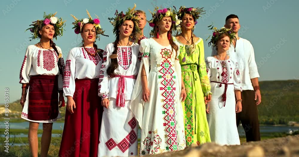 Group of beautiful Slavic women and men in folk dresses and costumes ...