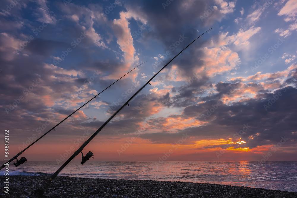 Two fishing rods on the beach, against the backdrop of a beautiful ...