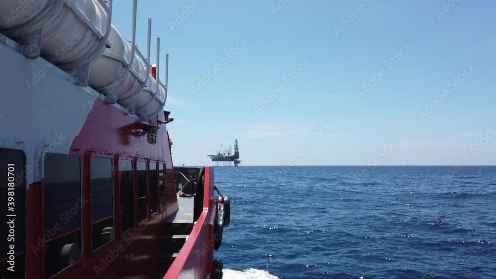 Crew boat sailing to the offshore jack up drilling rig in the middle of ...